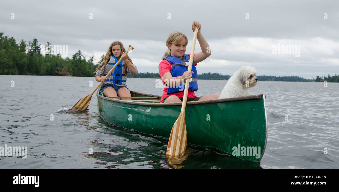 Two girls rowing a boat in a lake, Lake of The Woods, Ontario, Canada ...