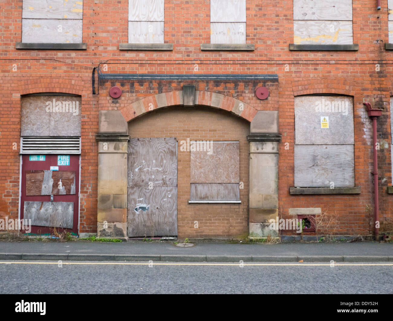 Man walking through the frame in front of an old abandoned and derelict ...