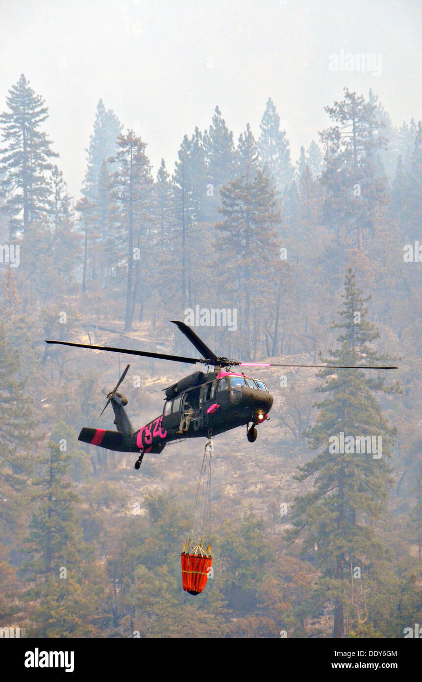 A US Army Black Hawk helicopter approaches the Cherry Lake Dam to fill ...