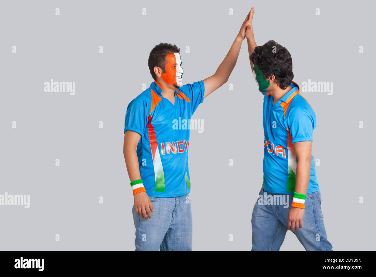 Male cricket fans in jerseys giving a high-five to each other over ...