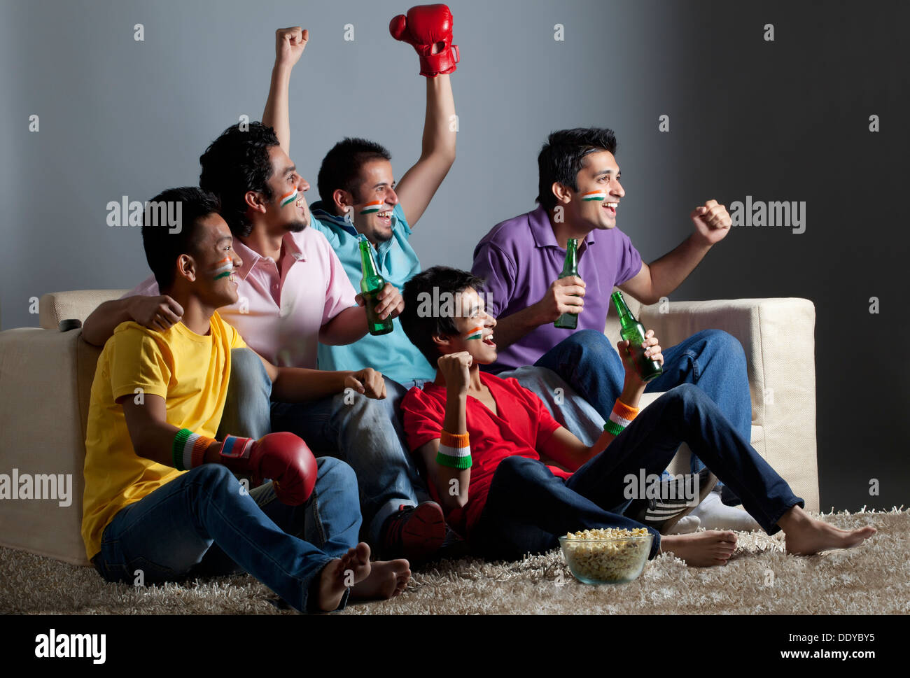 Enthusiastic male friends watching boxing match together at home Stock ...