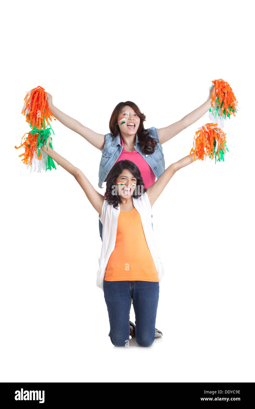 Portrait of excited young women cheering with Indian tricolor pom poms ...