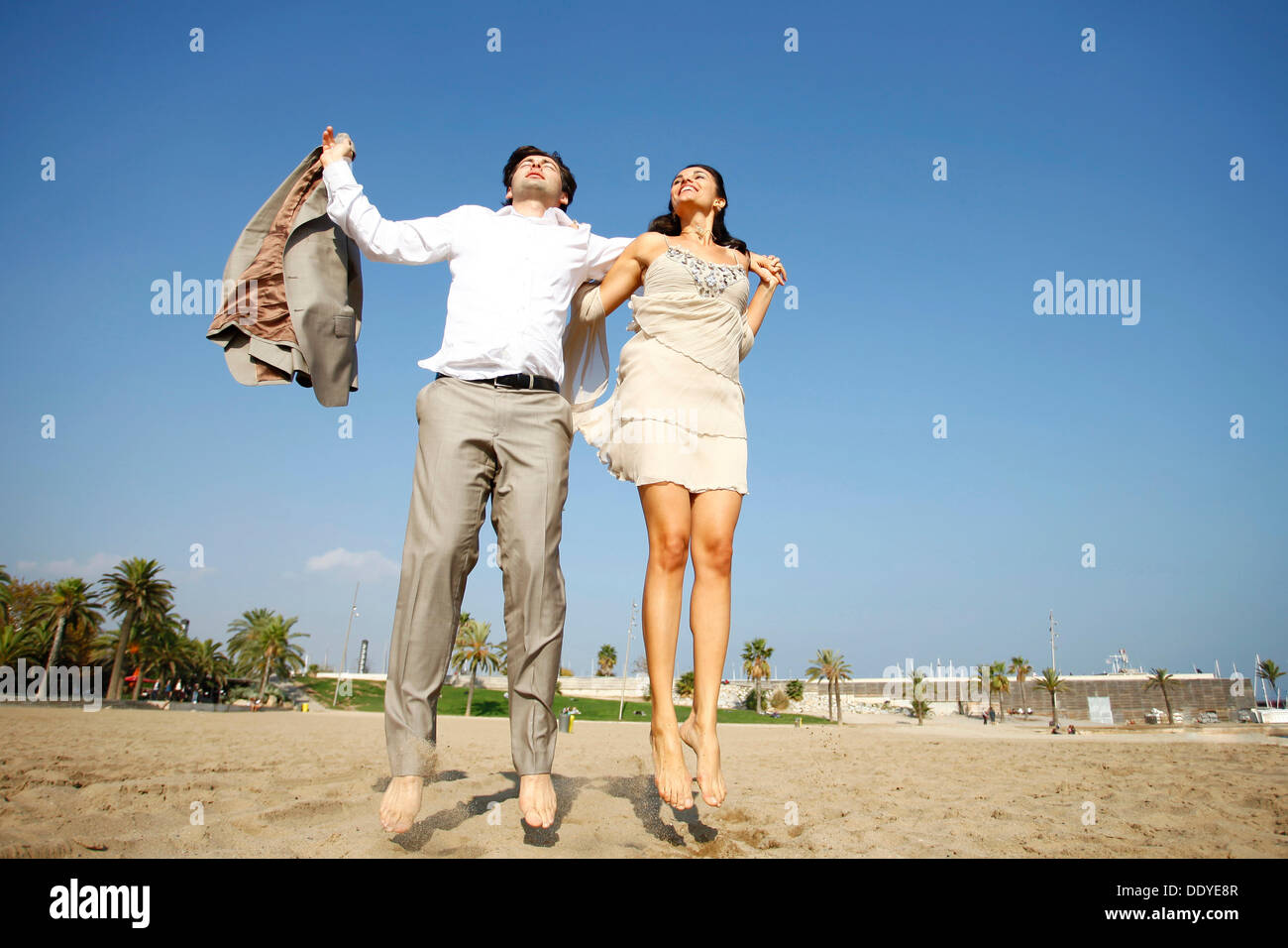 Couple jumping on the beach Stock Photo - Alamy