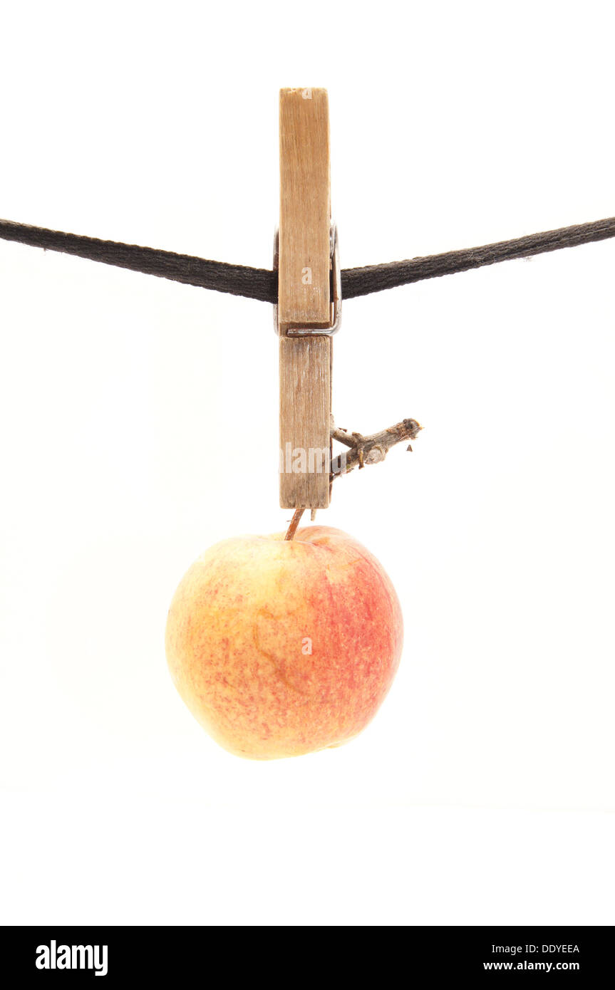 Apple, clothespin and rope on a white background Stock Photo - Alamy