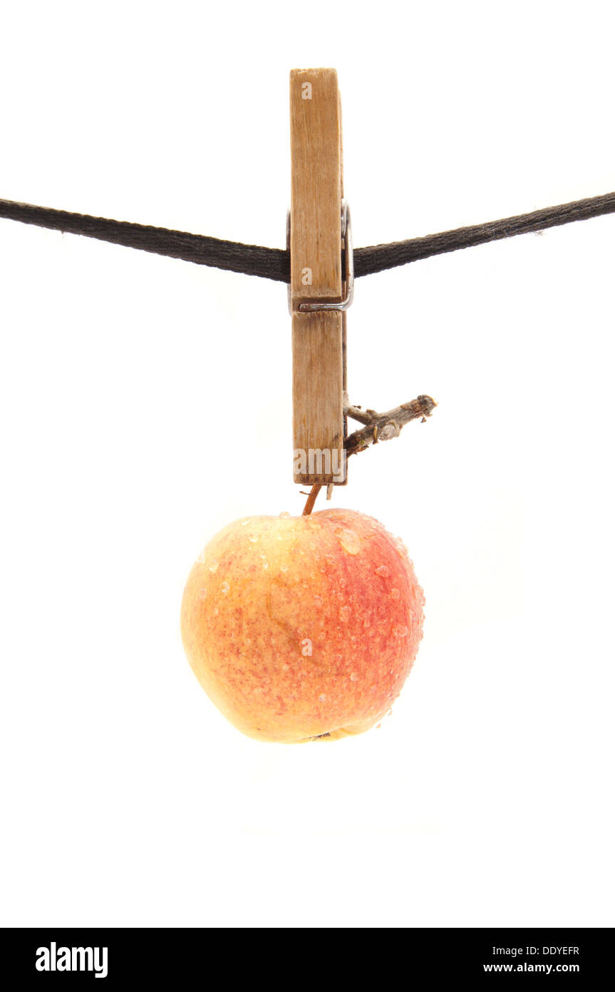 Apple, clothespin and rope on a white background Stock Photo - Alamy
