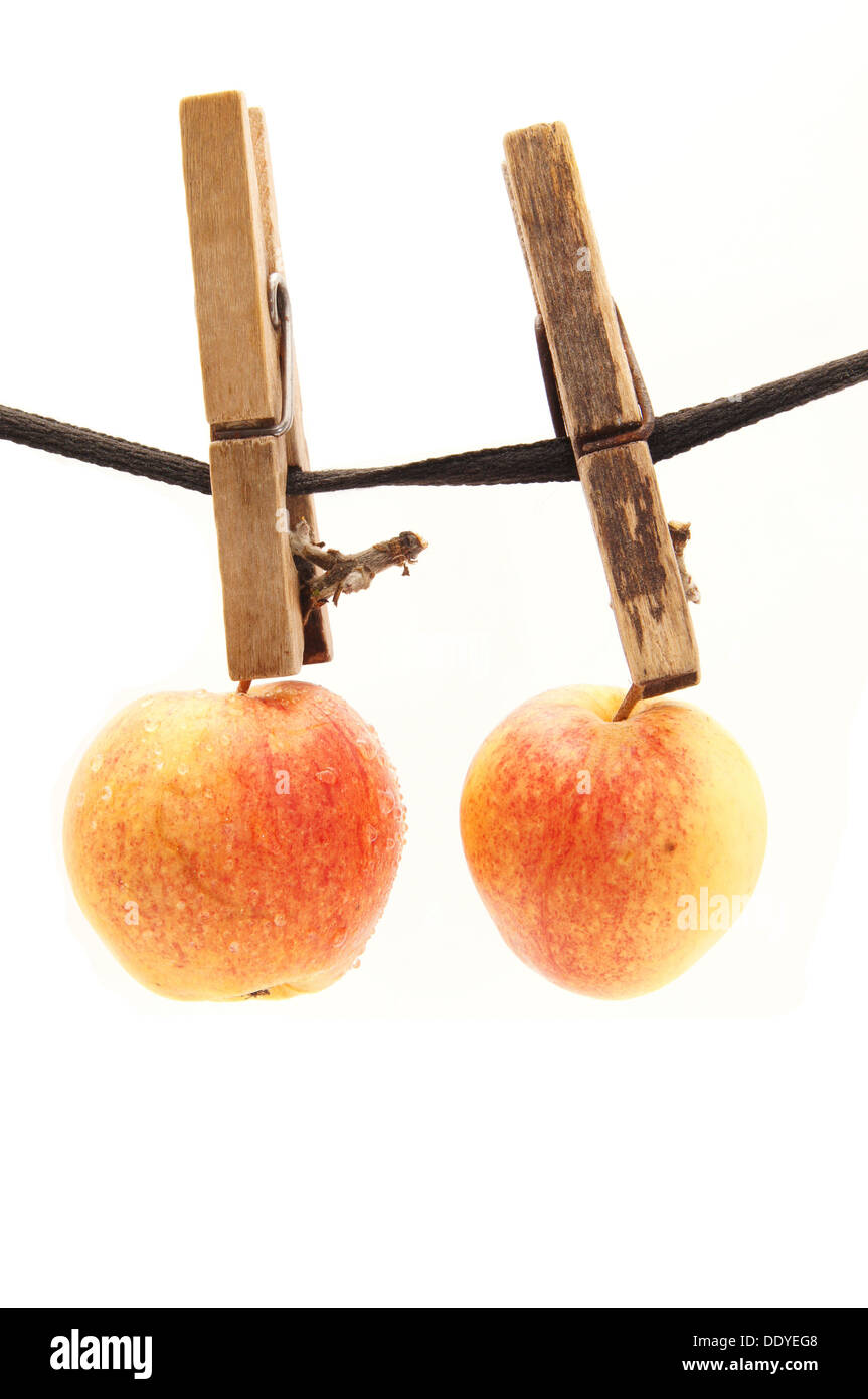 Apple, clothespin and rope on a white background Stock Photo - Alamy