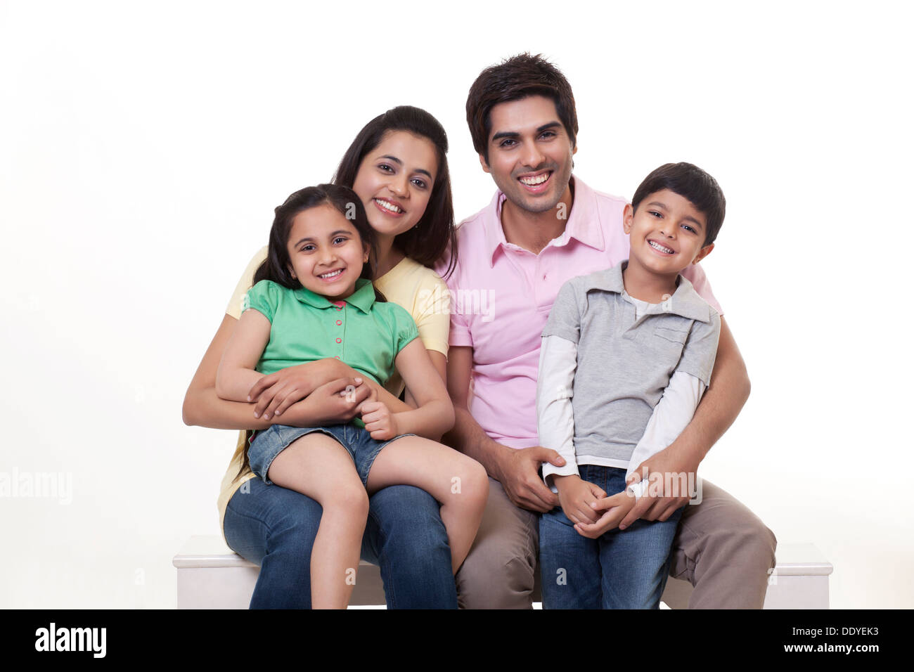 Portrait of a happy family sitting on bench over white background Stock ...