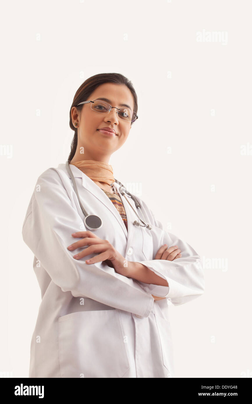 Low angle view of young confident female doctor standing against white ...