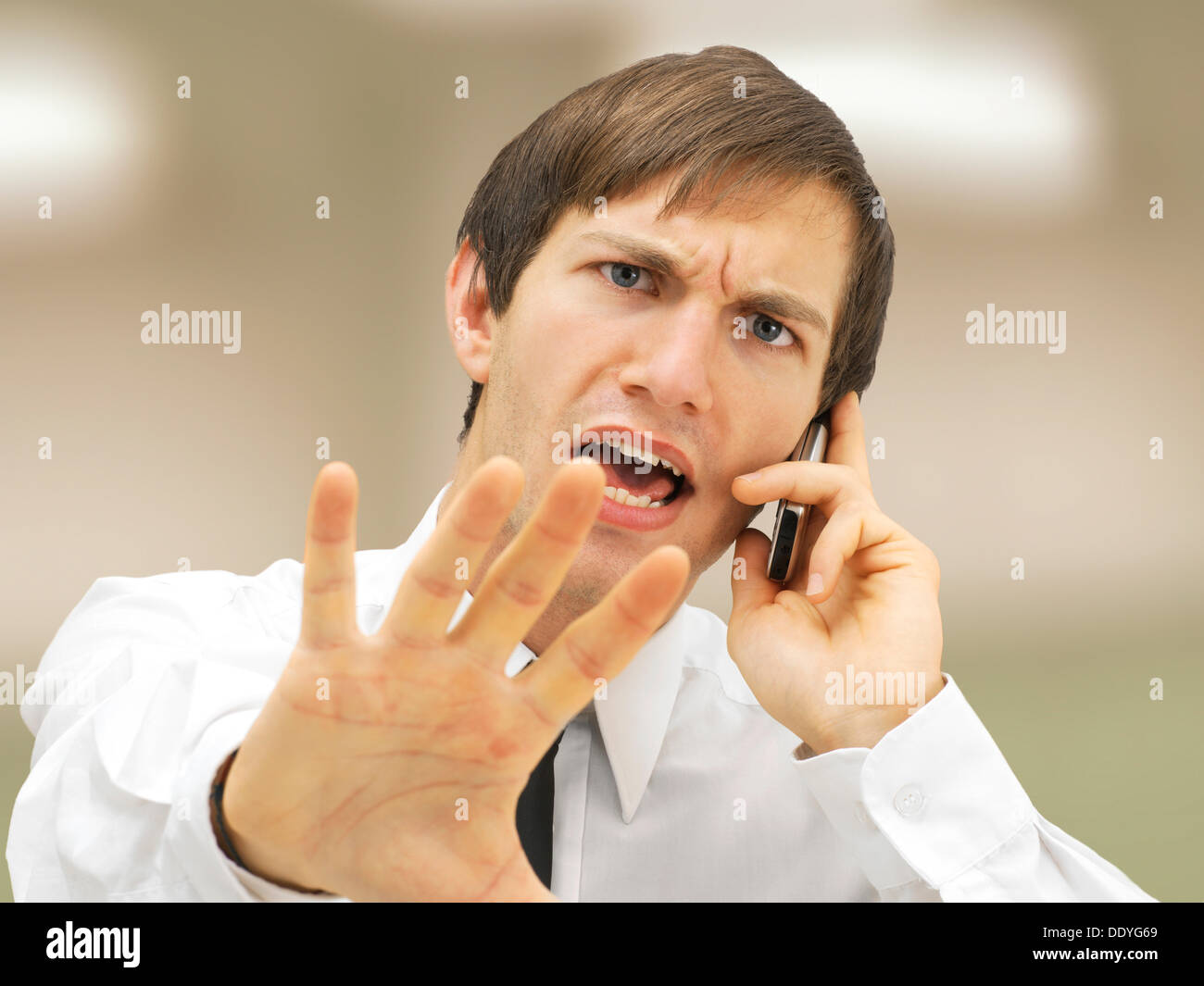 Aggressive businessman speaking on his mobile phone, portrait, stressed ...