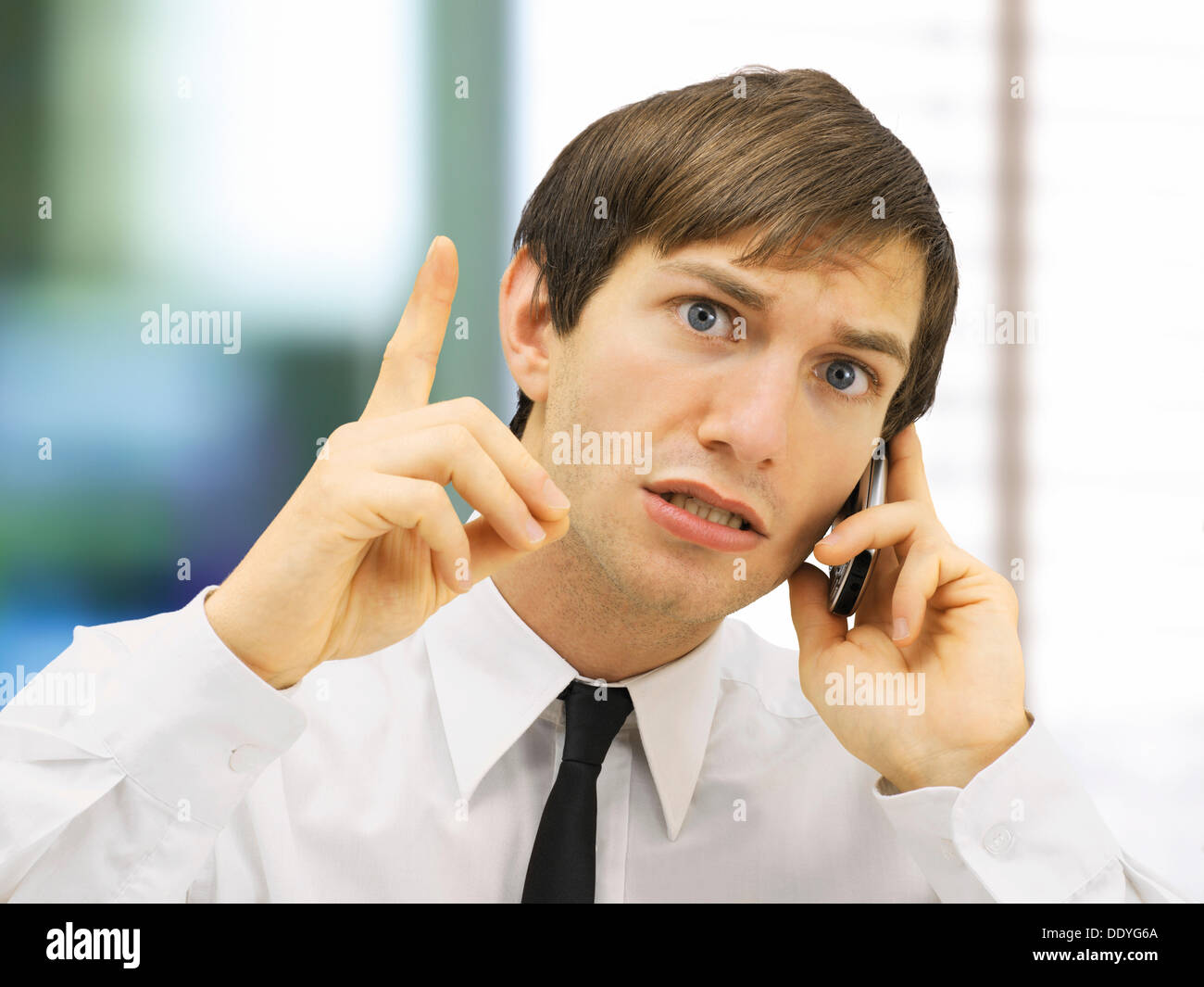 Stressed businessman speaking on his mobile phone, portrait, with an ...