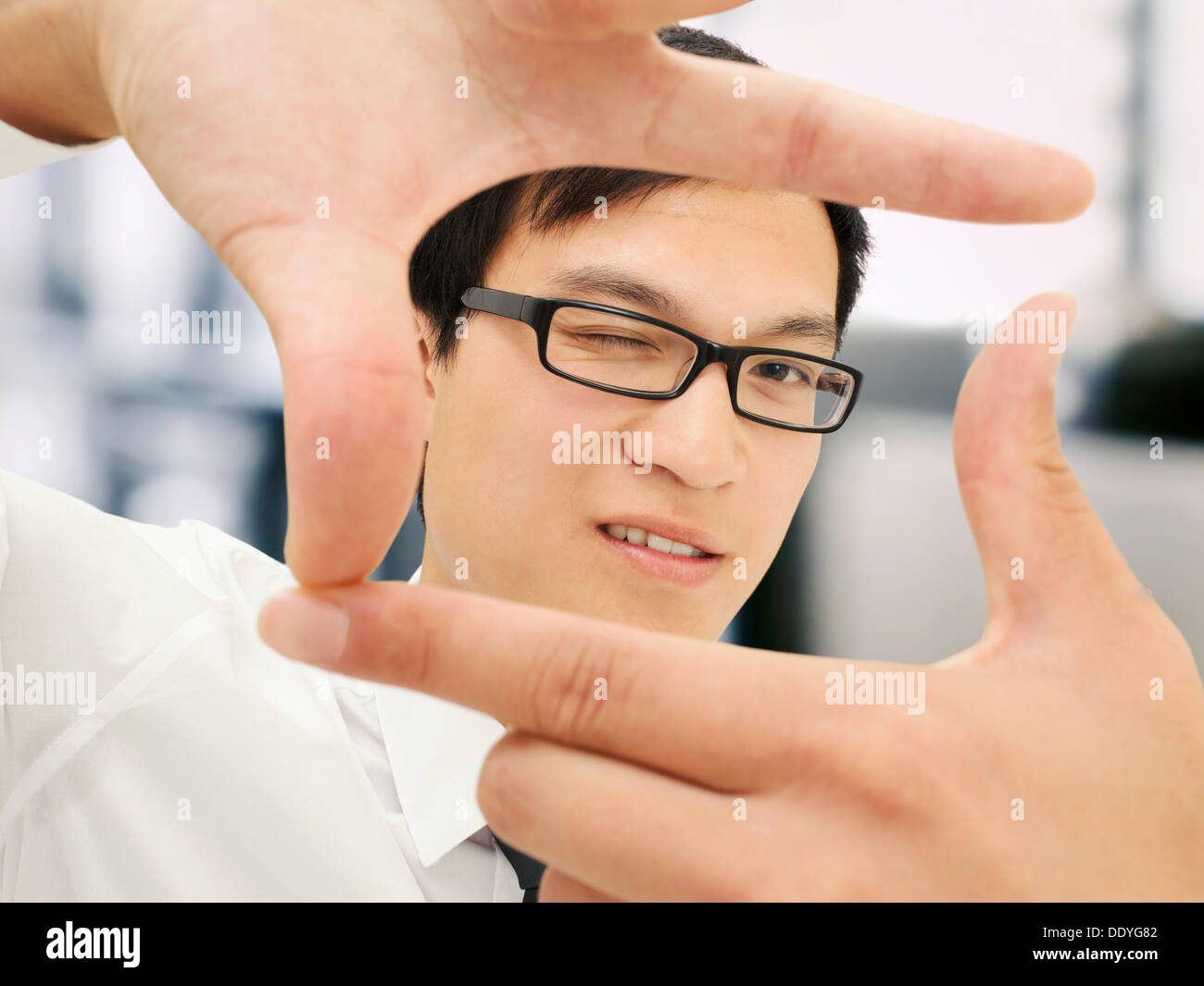 Young businessman, Asian, with glases, friendly, holding fingers as a ...