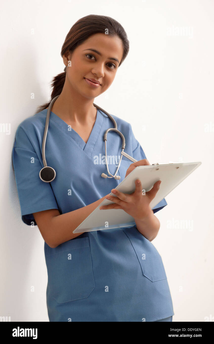 Portrait of young female surgeon writing notes isolated over white ...