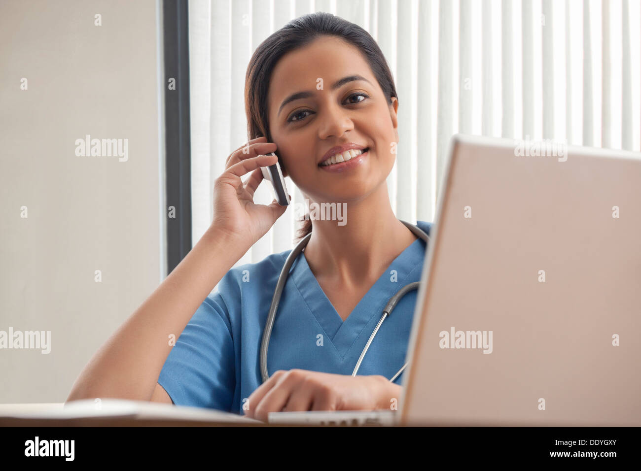 Portrait of female surgeon using mobile phone at desk Stock Photo - Alamy