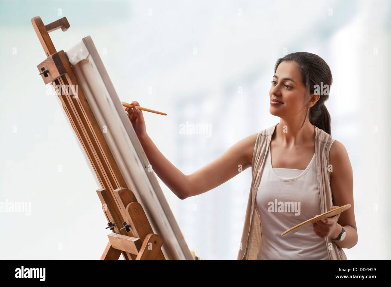 Young woman painting on canvas Stock Photo - Alamy