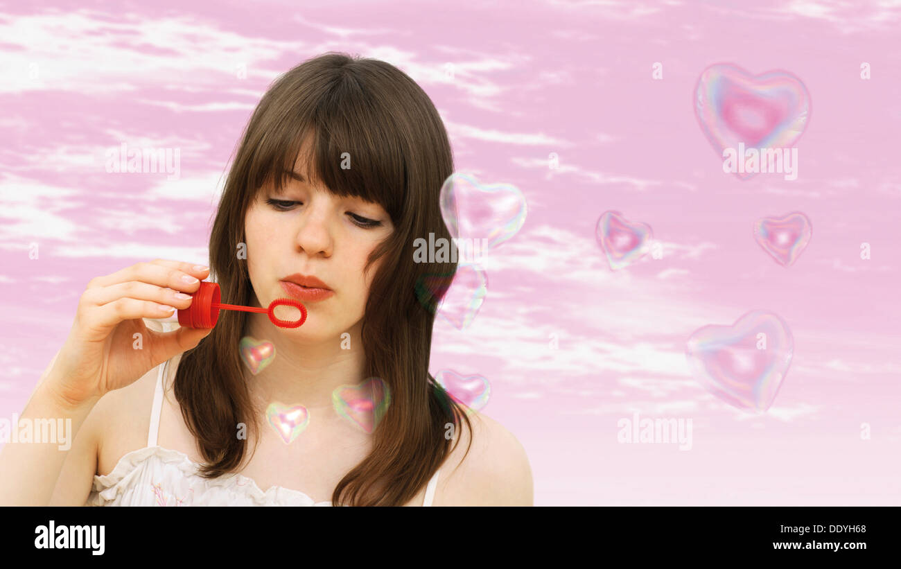Young girl blowing heart-shaped soap-bubbles Stock Photo - Alamy