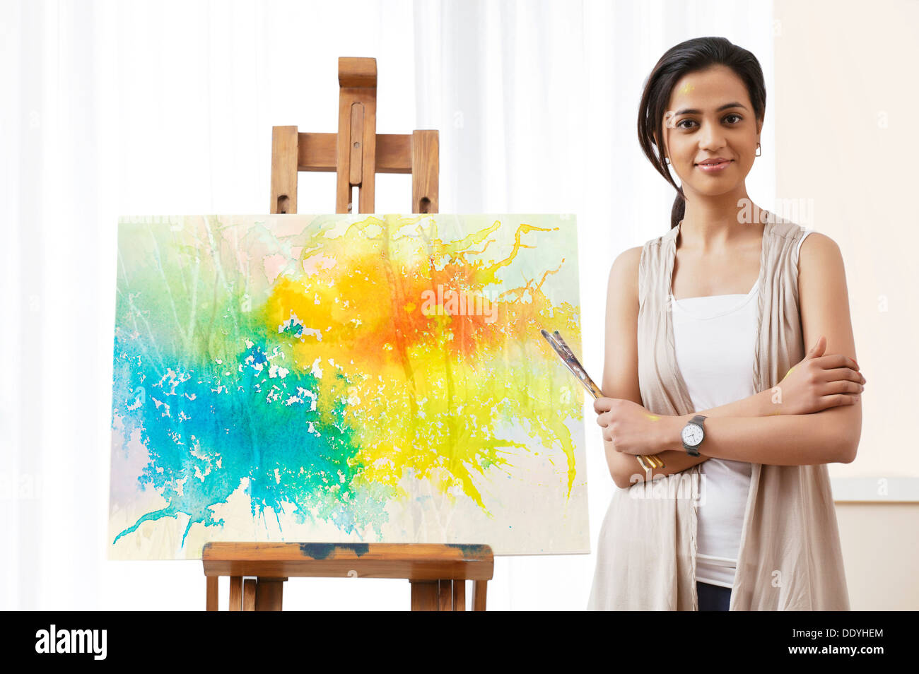 Portrait of confident female artist standing by painting Stock Photo ...