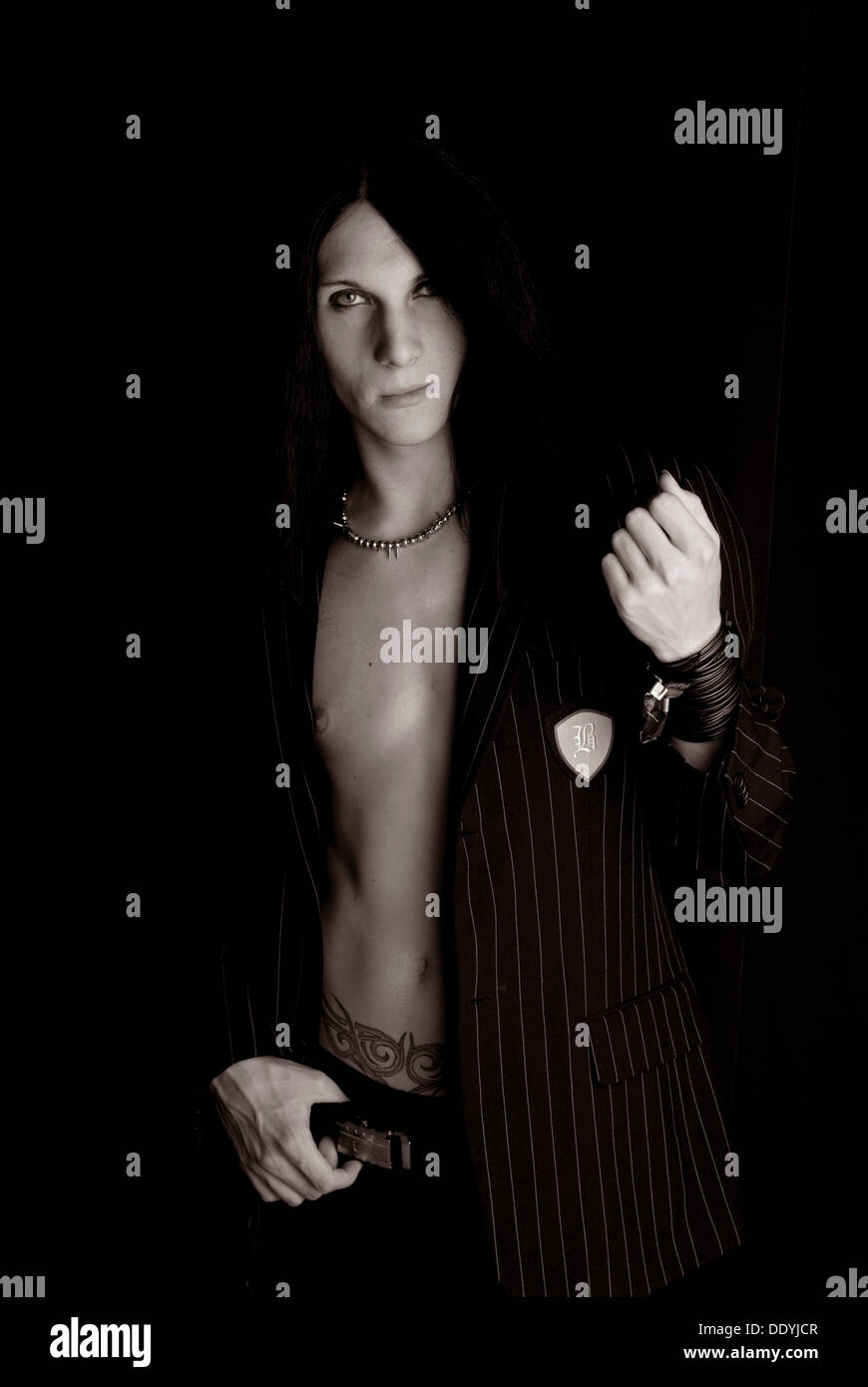 Man dressed in a Goth style, musician, standing and looking serious ...