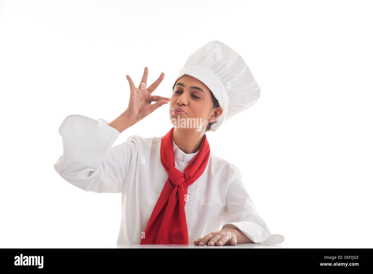 Female chef making tip with her hand in front of mouth to symbolize ...