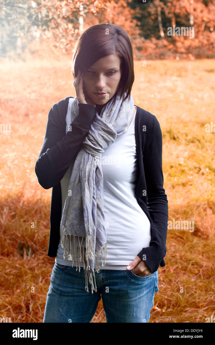 Standing young woman, sad Stock Photo - Alamy