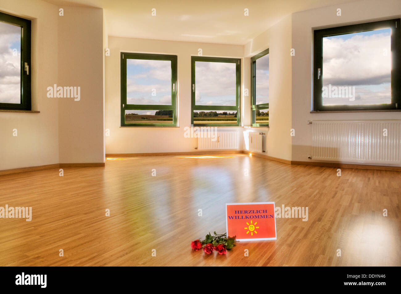 Welcome sign and roses on the floor, large living room with windows and ...