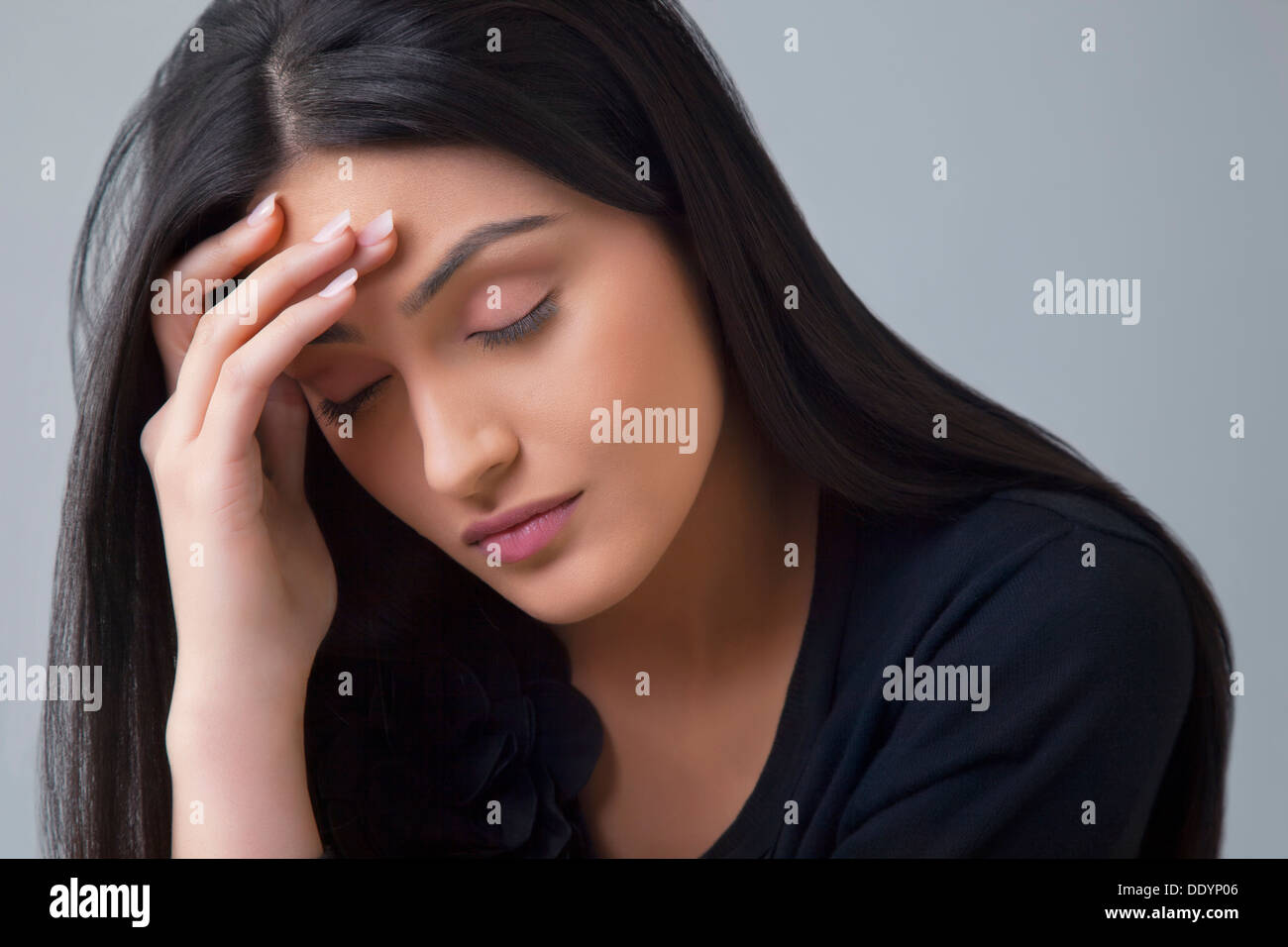 Young Indian woman suffering from headache isolated over colored ...