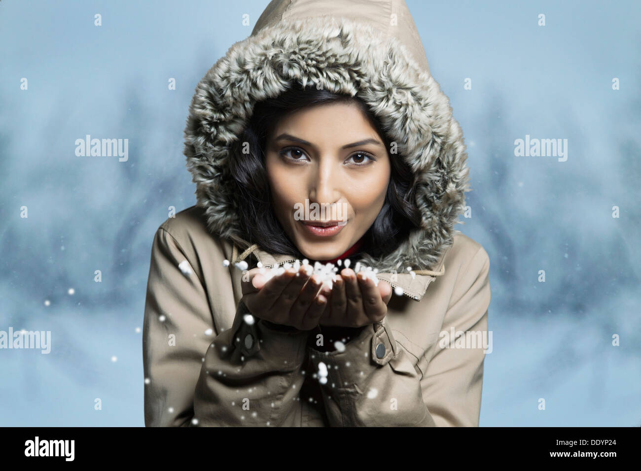 Portrait of woman blowing snow from her hands Stock Photo - Alamy