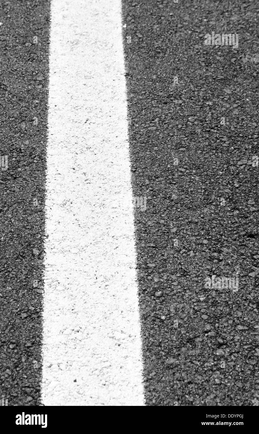 vertical white line painted across the black asphalt road Stock Photo ...