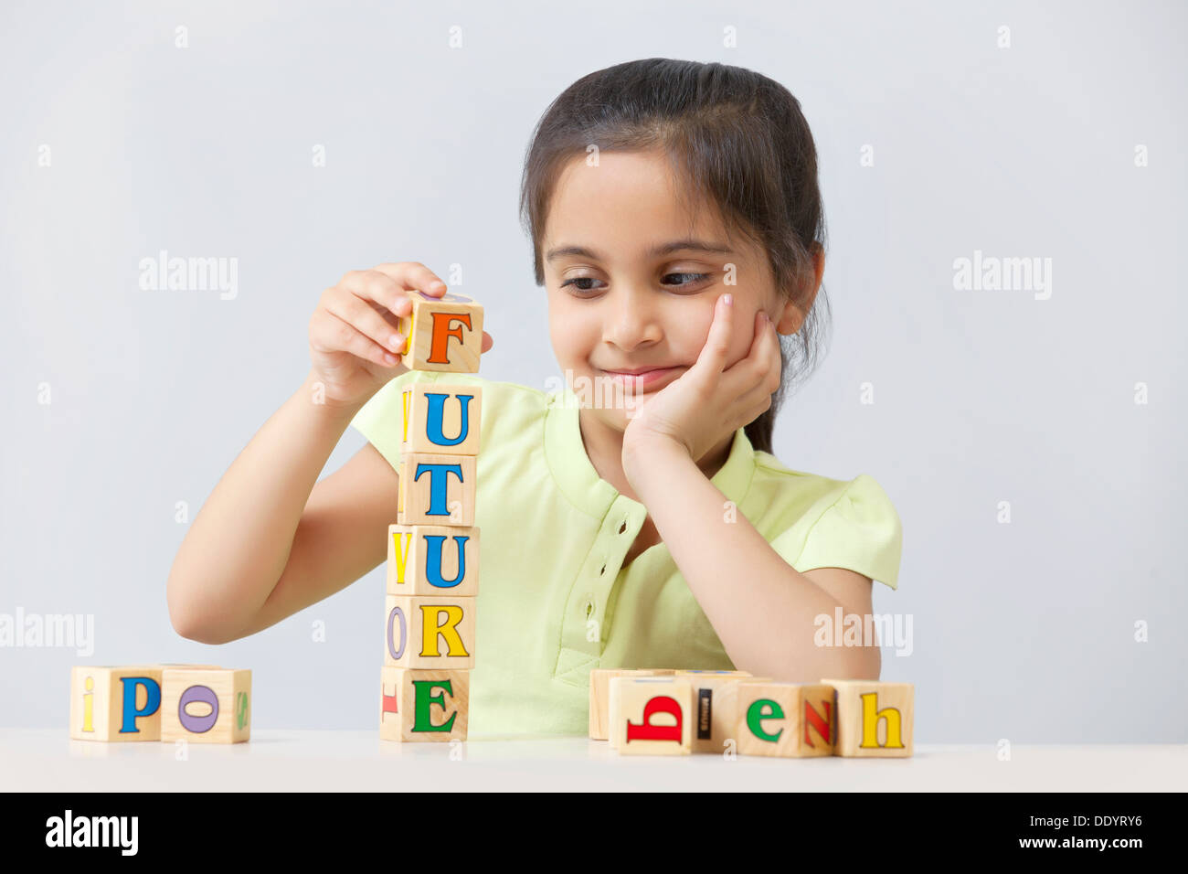 Young girl stacking blocks isolated over gray background Stock Photo ...