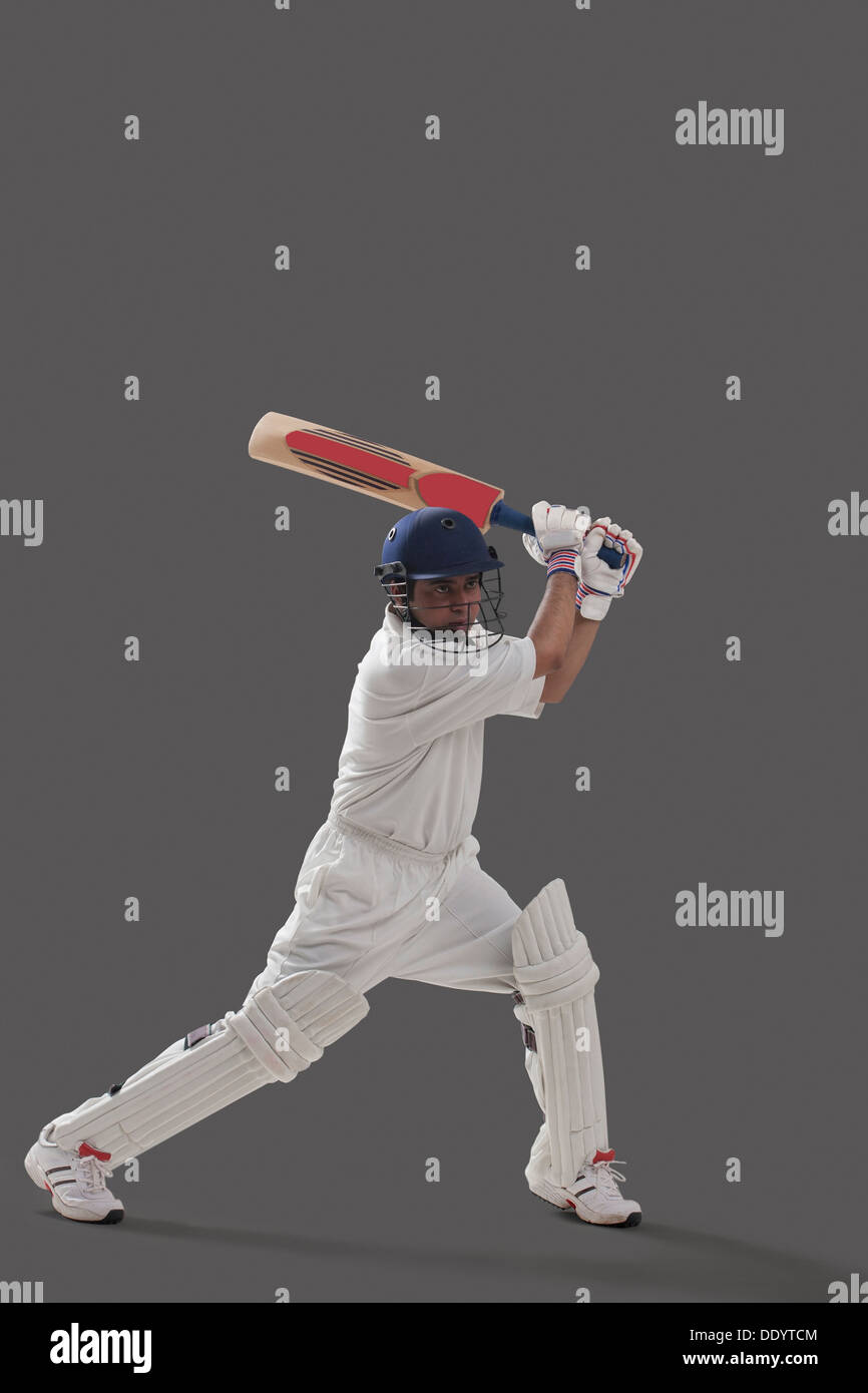 Young man playing cricket isolated over gray background Stock Photo - Alamy