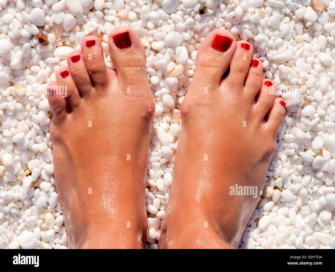Female feets on the small white stones Stock Photo - Alamy