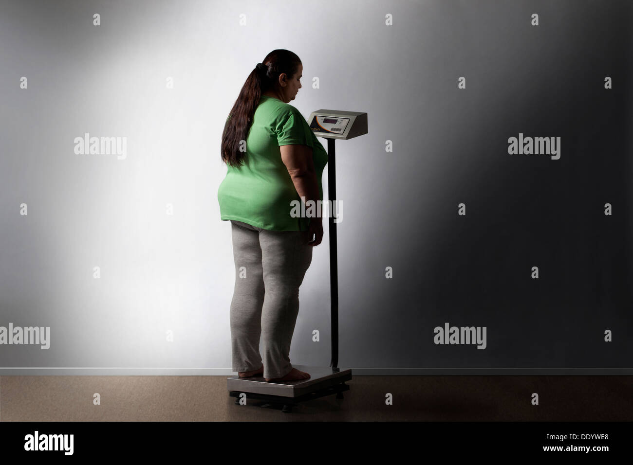 Obese woman checking her weight Stock Photo - Alamy