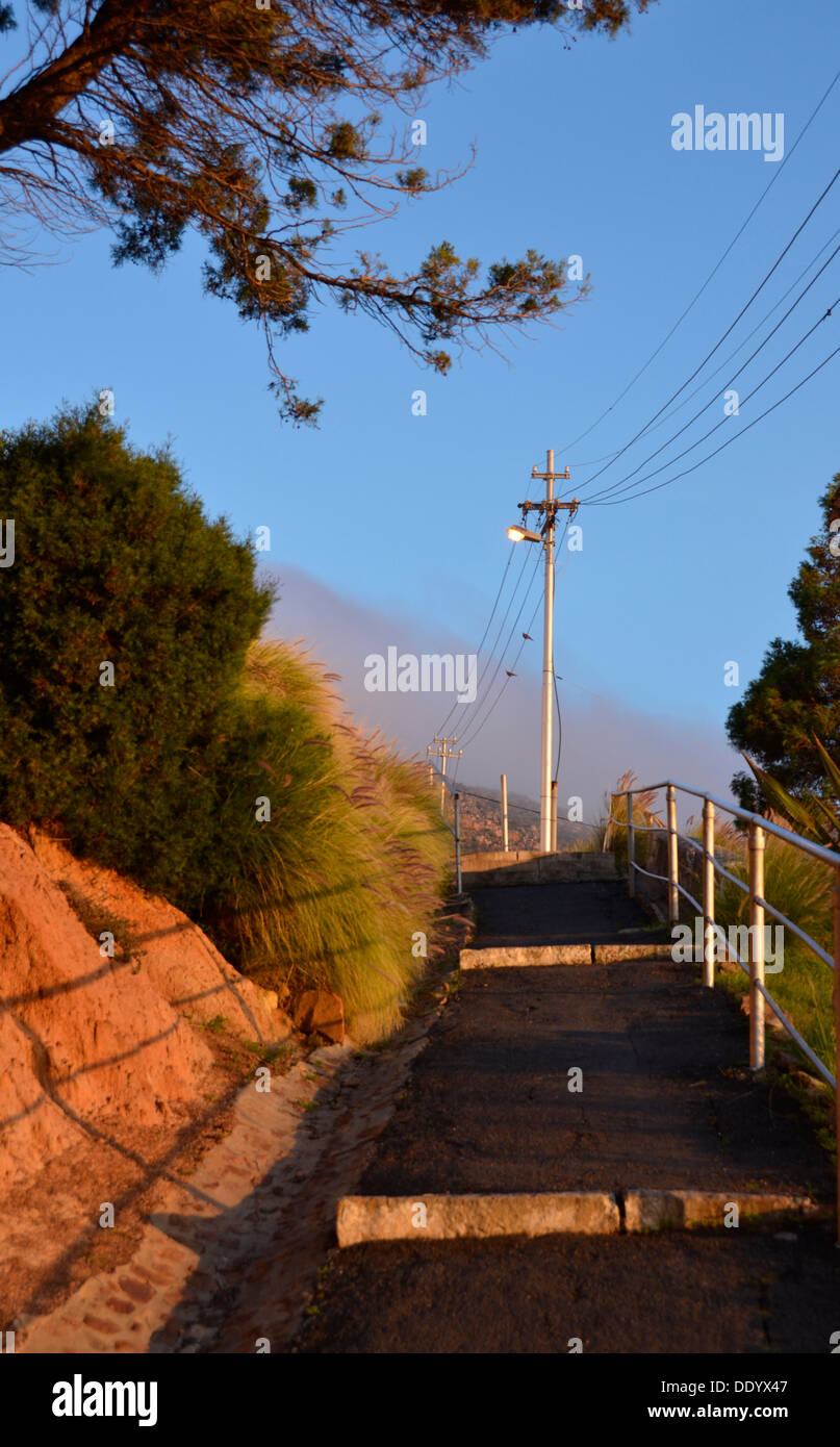 Old paved path with morning shadows, leading upwards past a lamp post ...