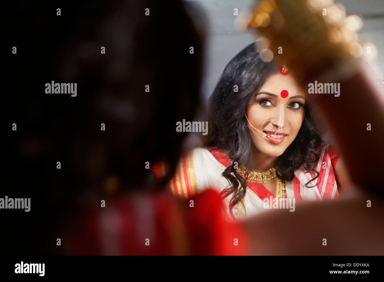 Bengali woman looking at herself in the mirror Stock Photo - Alamy