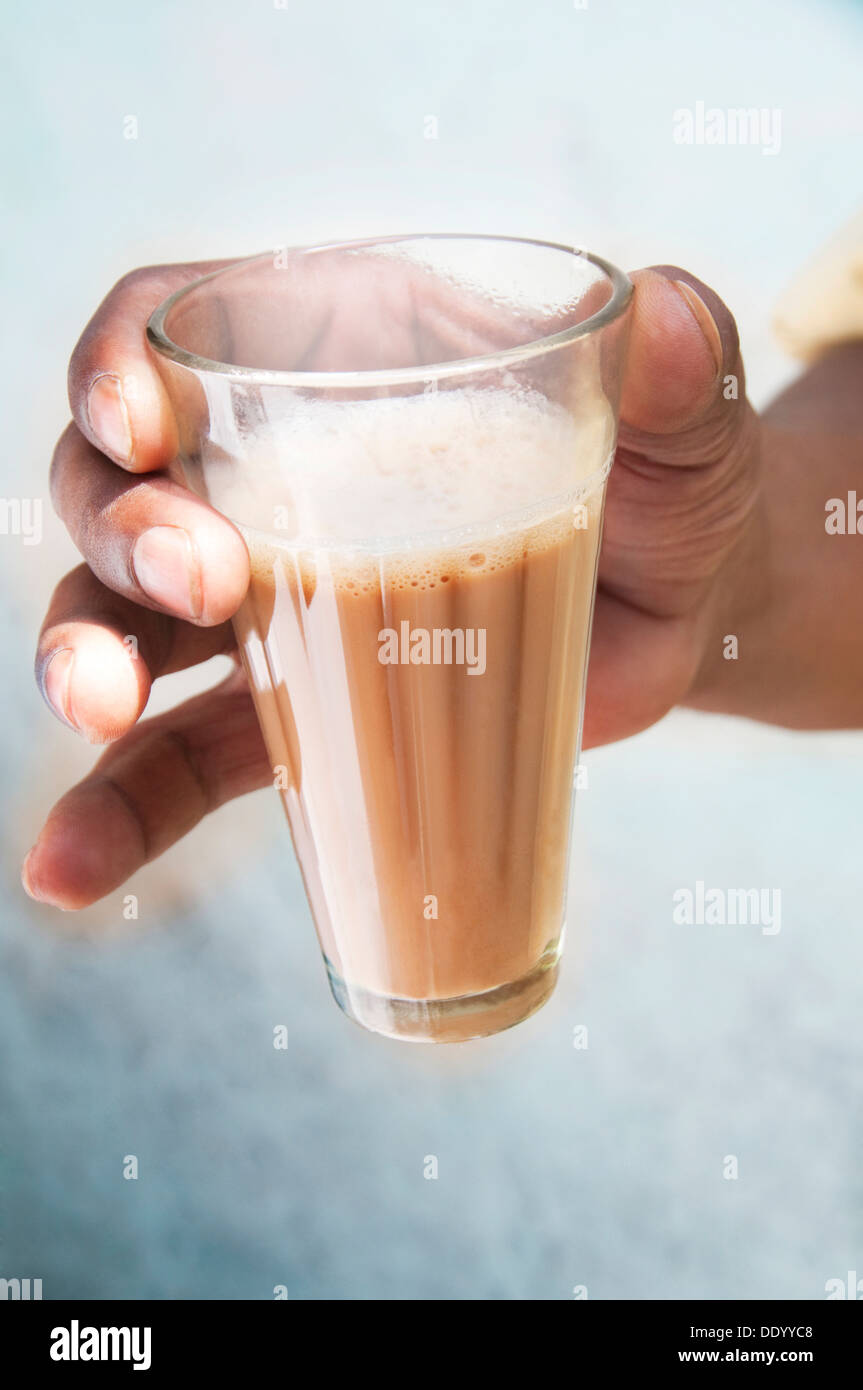 Close-up of man's hand holding glass of chai Stock Photo - Alamy