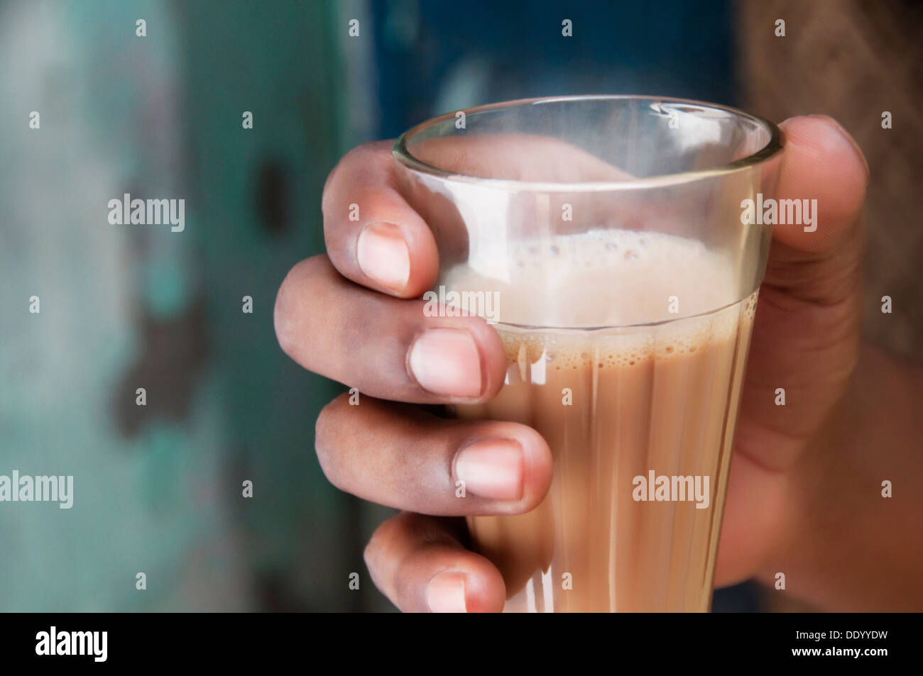 Close-up shot of man's hand holding glass of Indian milk tea Stock ...