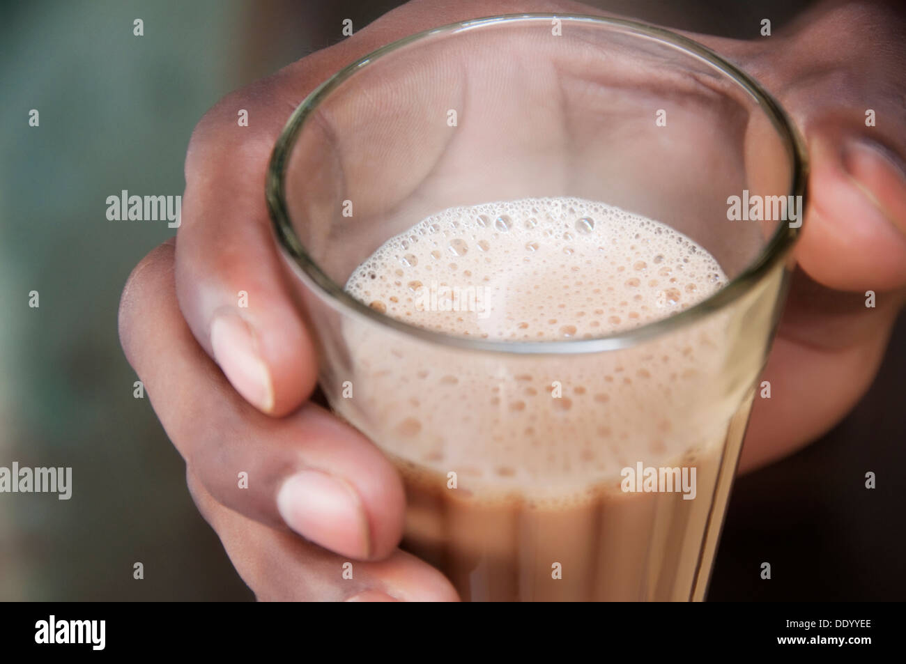 Close-up shot of man's hand holding glass of chai Stock Photo - Alamy