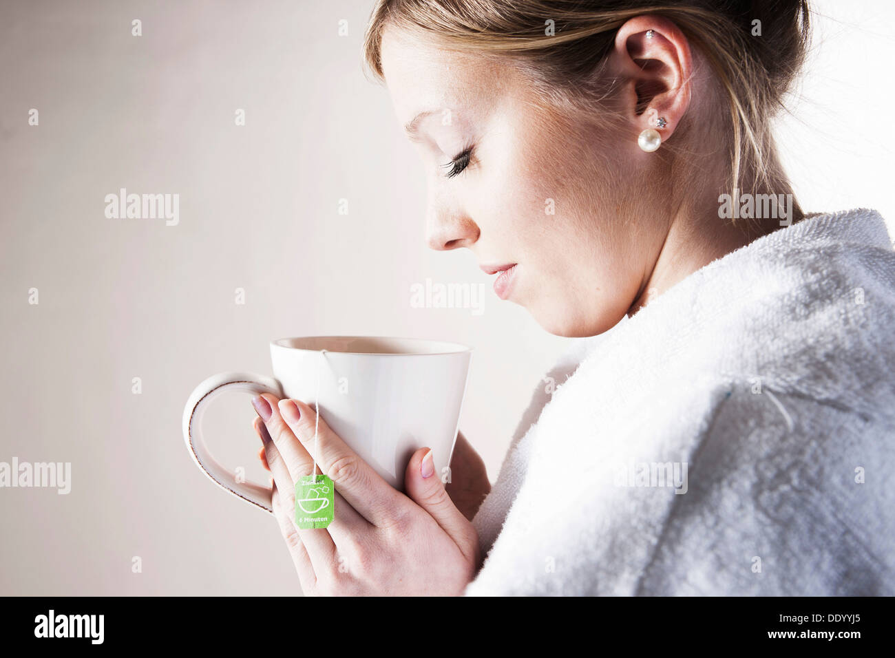 Young woman holding a cup of tea in her hand and relaxing Stock Photo ...