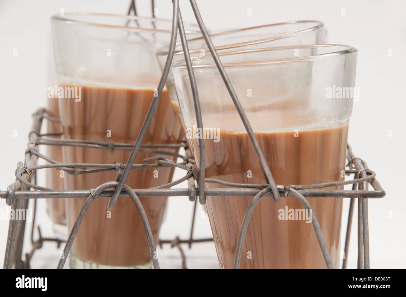Close-up of milk tea kept in a metal grid tray isolated over white ...