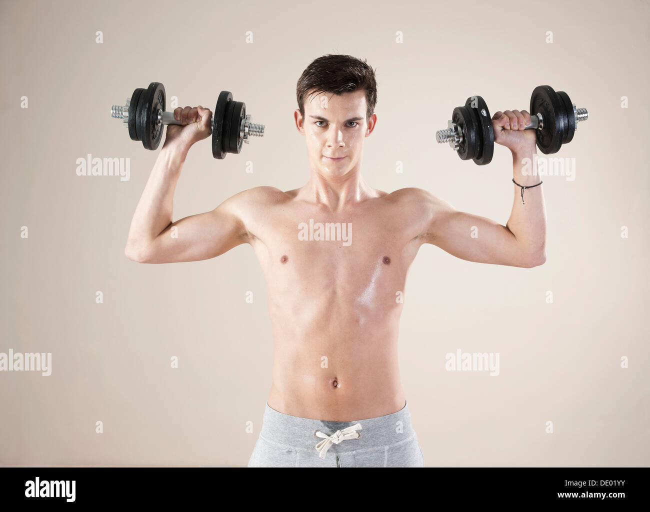 Young man doing weight training with dumbbells Stock Photo - Alamy