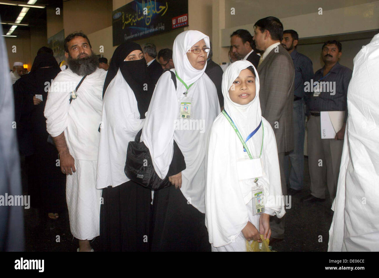 Pakistani pilgrims stand in a queue at Jinnah International Airport ...