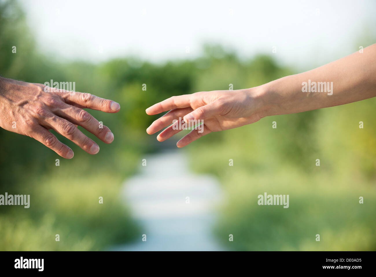 Couple reaching out to hold hands Stock Photo - Alamy