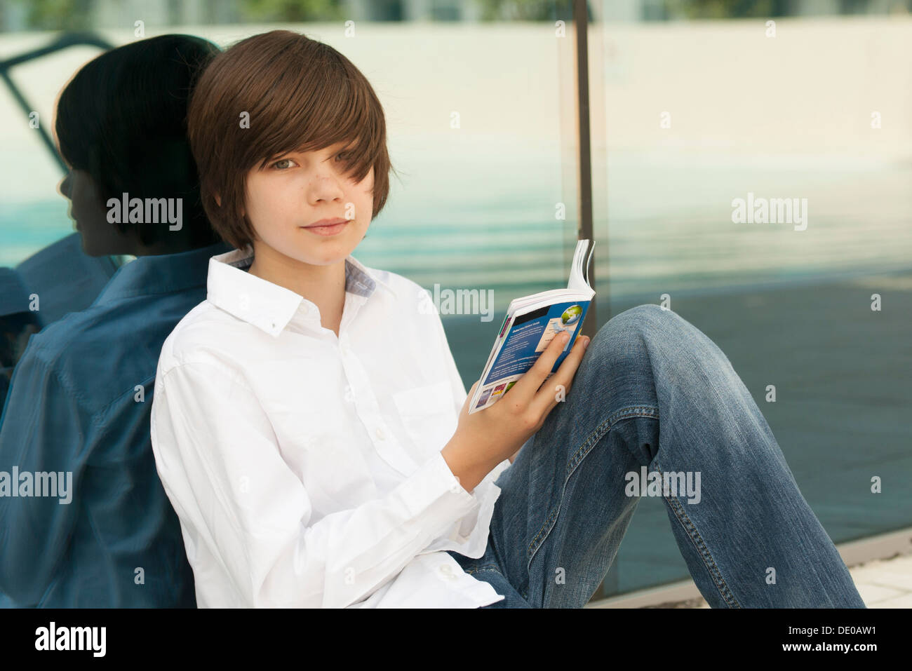Teenage boy reading guidebook Stock Photo - Alamy