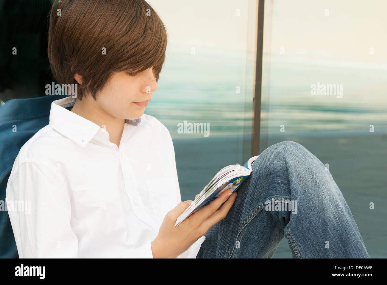 Teenage boy reading book Stock Photo - Alamy