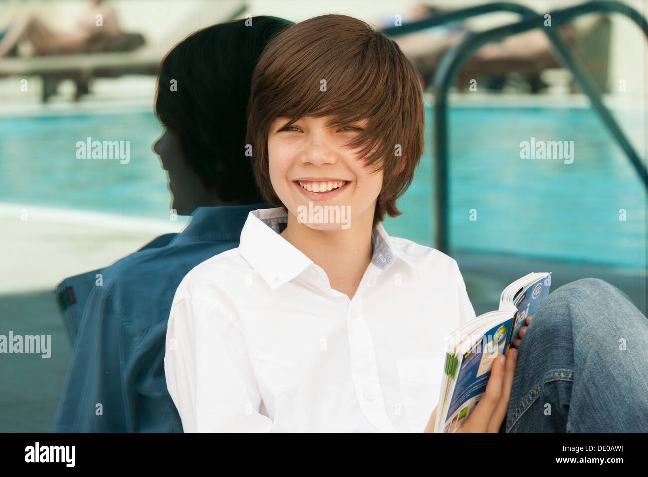 Teenage boy reading guidebook Stock Photo - Alamy