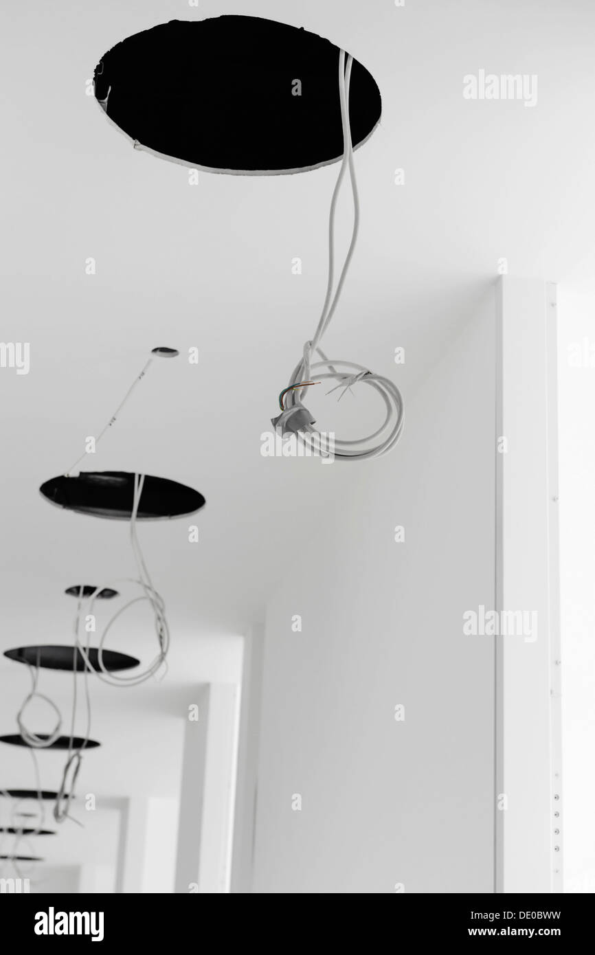 Building site, interior, electrical cables hanging from holes in the ...