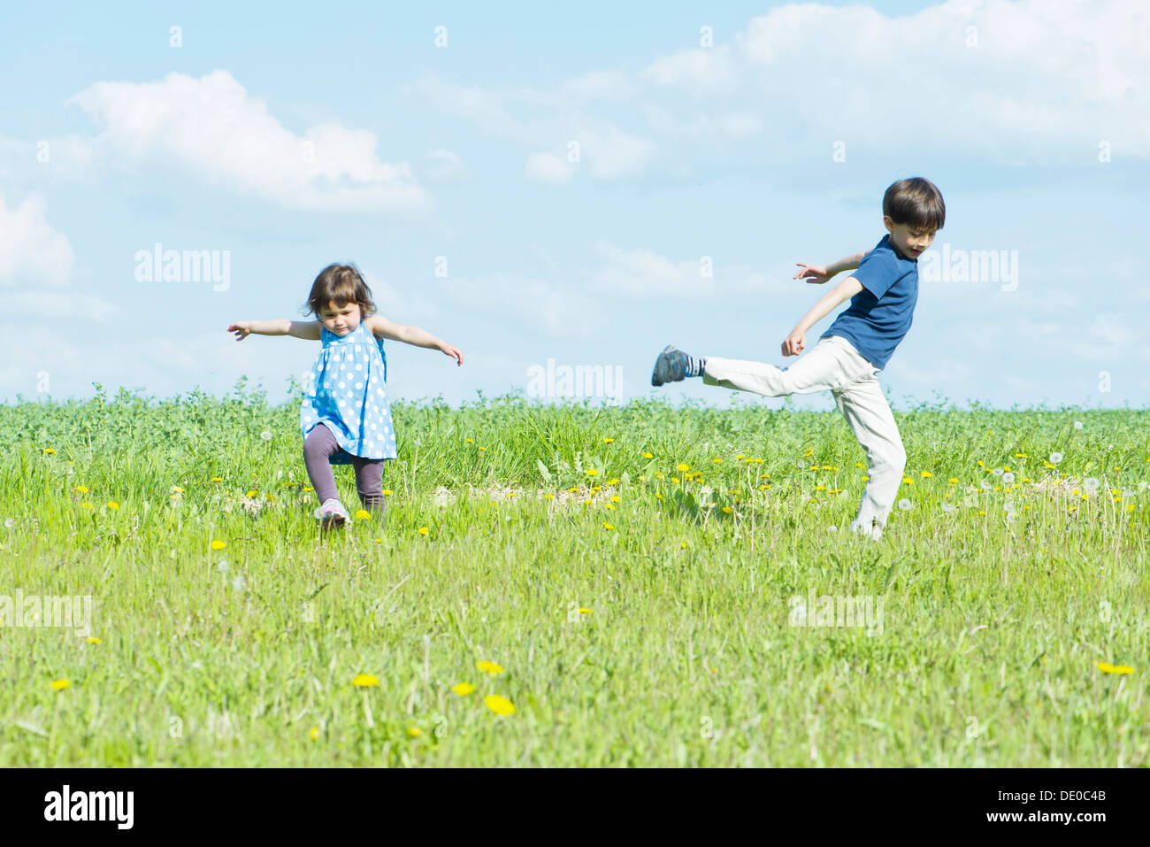 Children running in field with arms out Stock Photo - Alamy