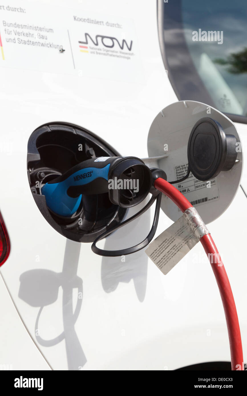 Electrical plug, a Volkswagen Golf being charged in front of the ...