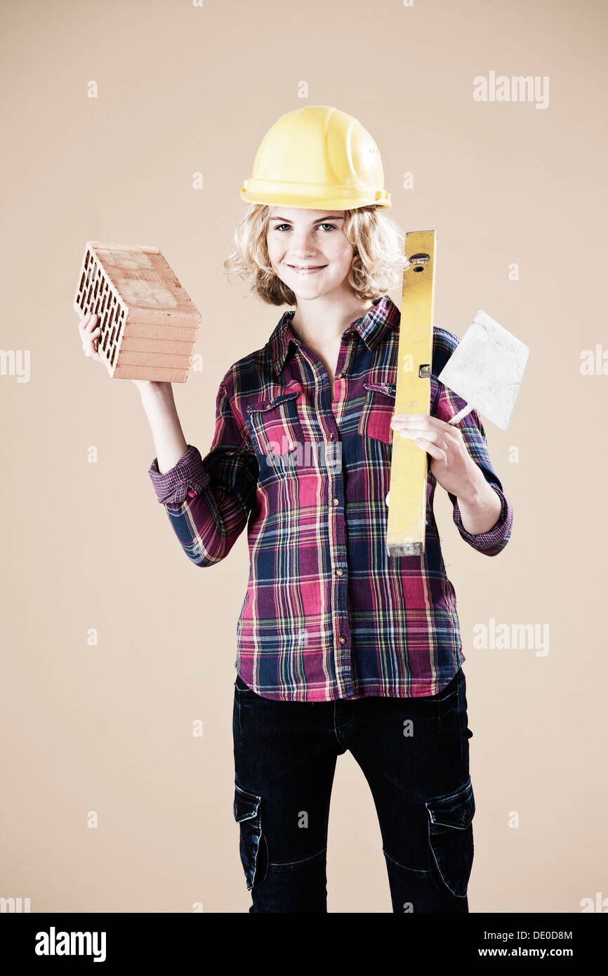 Girl holding a spirit level and a brick Stock Photo - Alamy
