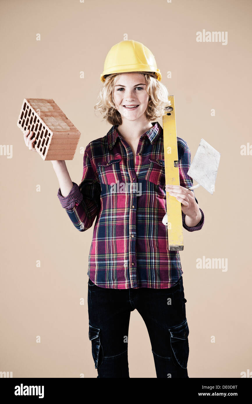 Girl holding a spirit level and a brick Stock Photo - Alamy