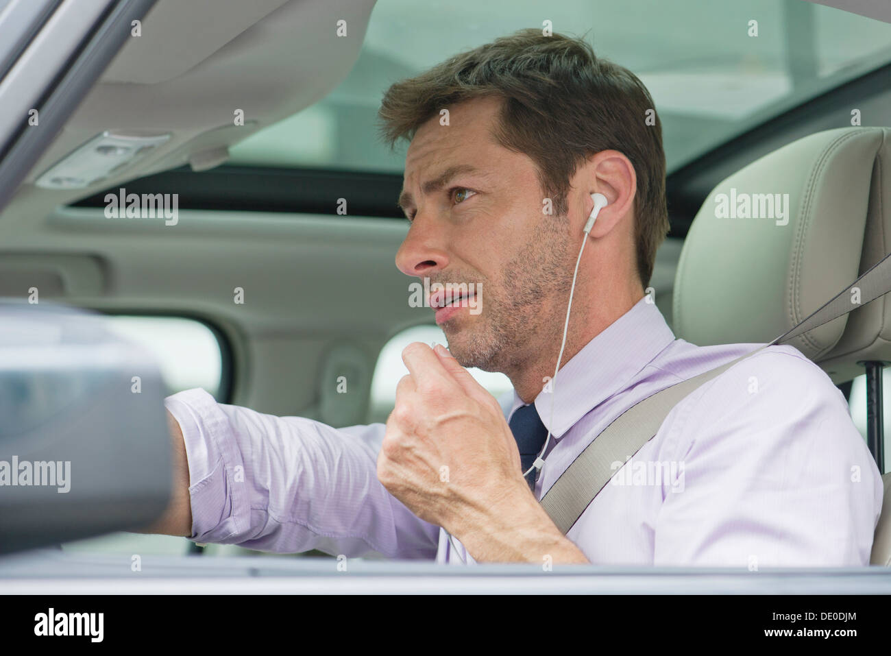 Man using earphone headset while driving Stock Photo - Alamy